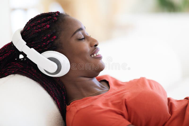 Smiling Relaxed Black Woman In Wireless Headphones Listening Music At