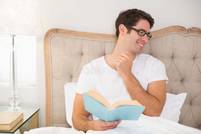 Smiling Relaxed Man Reading Book in Bed Stock Image - Image of book ...