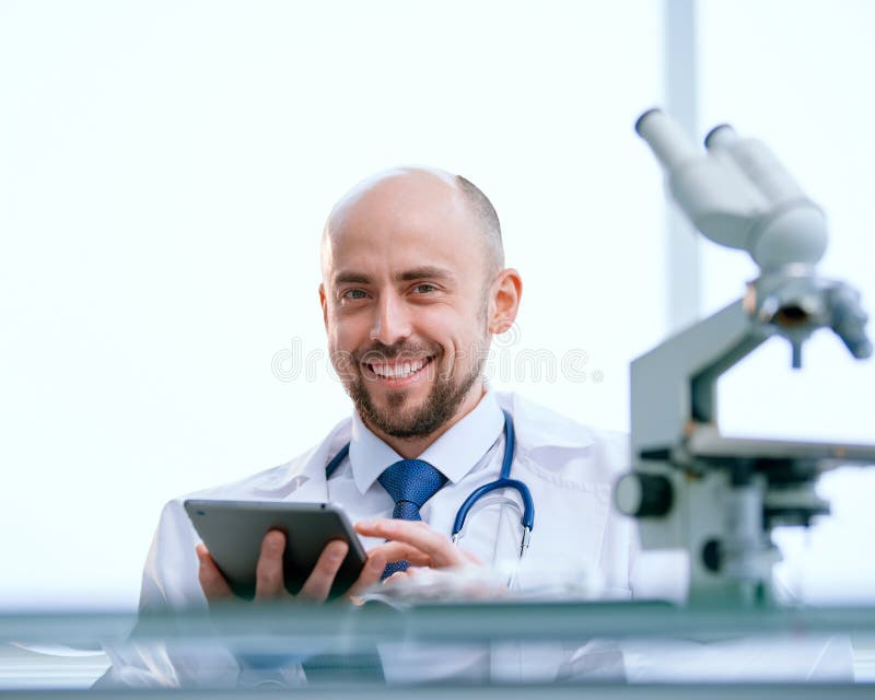 Smiling Researcher with a Digital Tablet Sitting in Front of a ...