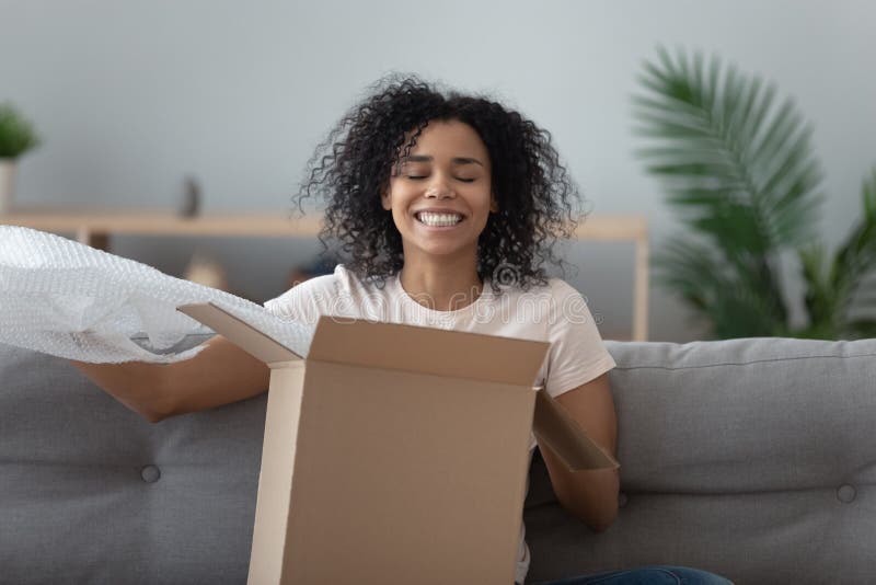 Smiling Satisfied African American Woman Client Unboxing Parcel Stock