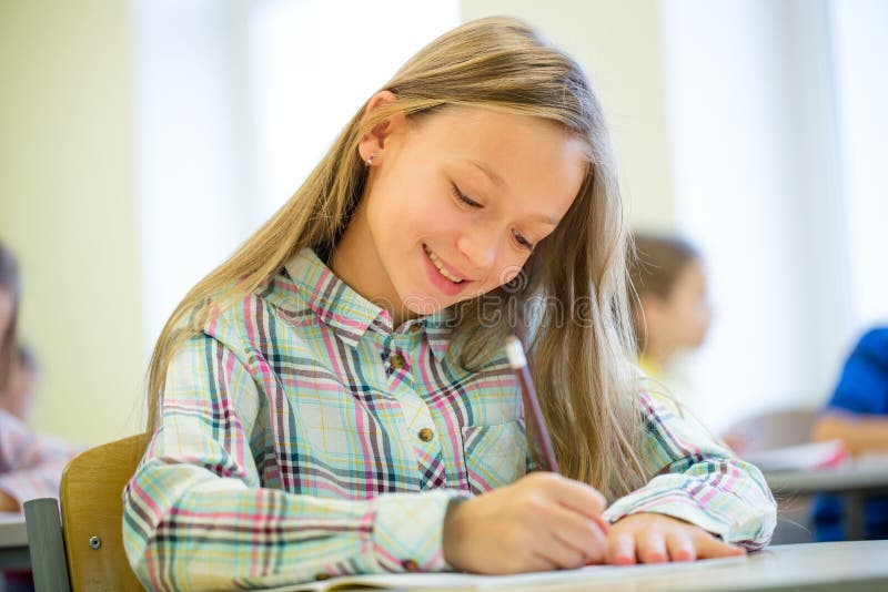 Smiling School Girl Writing Test in Classroom Stock Image - Image of ...
