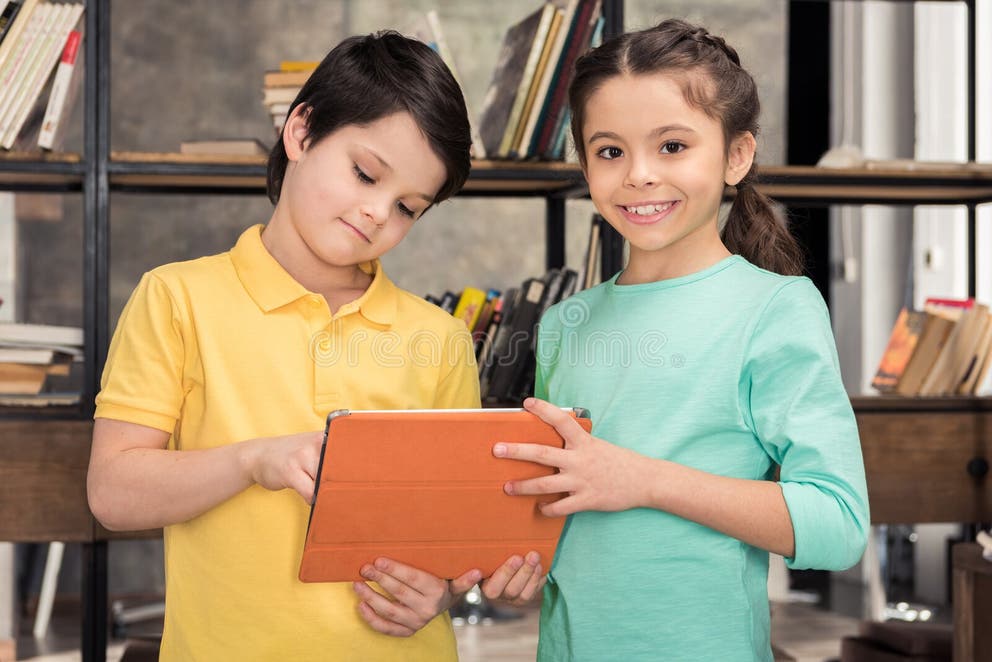 Smiling Schoolchildren Using Digital Tablet Together Stock Image ...
