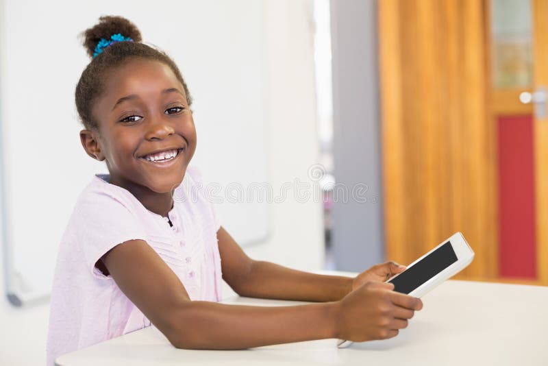 Smiling Schoolgirl Using Digital Tablet in Classroom at School Stock ...
