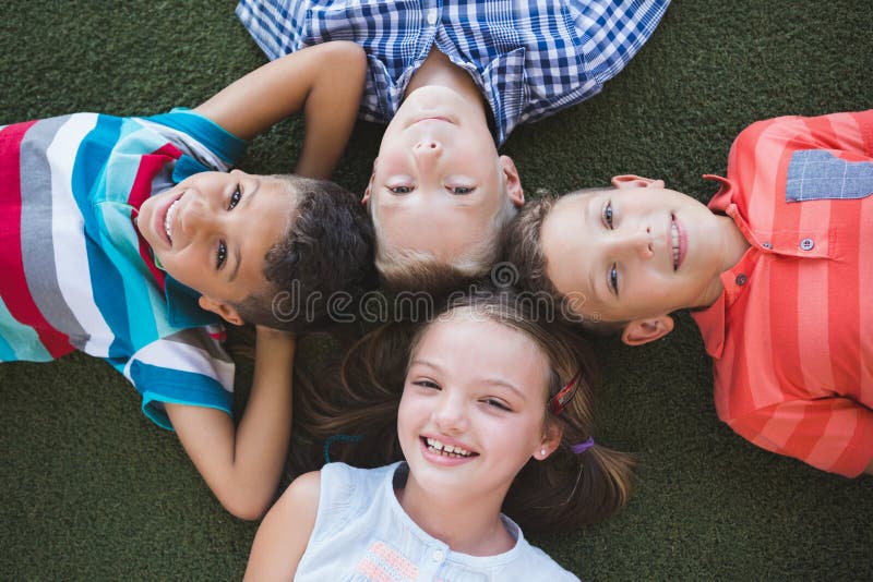 Smiling Schoolkids Lying on Grass in Campus Stock Image - Image of ...