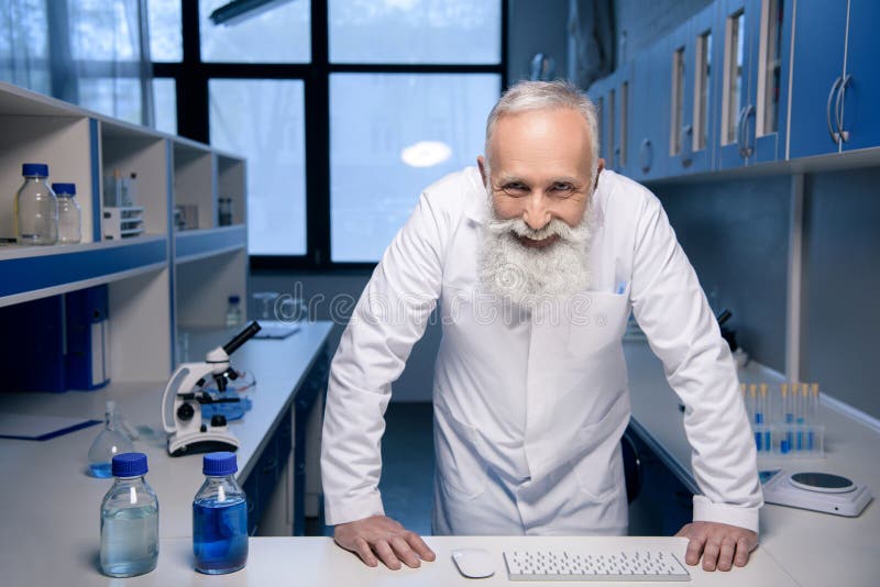 Smiling Scientist with Hands on Table Looking at Camera in Laboratory ...