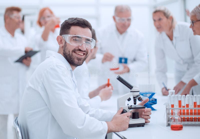 Smiling Scientist Sitting at a Laboratory Table . Stock Photo - Image ...