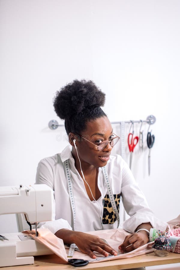 Smiling Seamstress Looking at Camera with Sewing Machine Stock Photo ...
