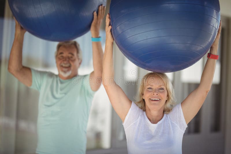 Smiling Senior Couple Exercising with Exercise Ball Stock Image - Image ...