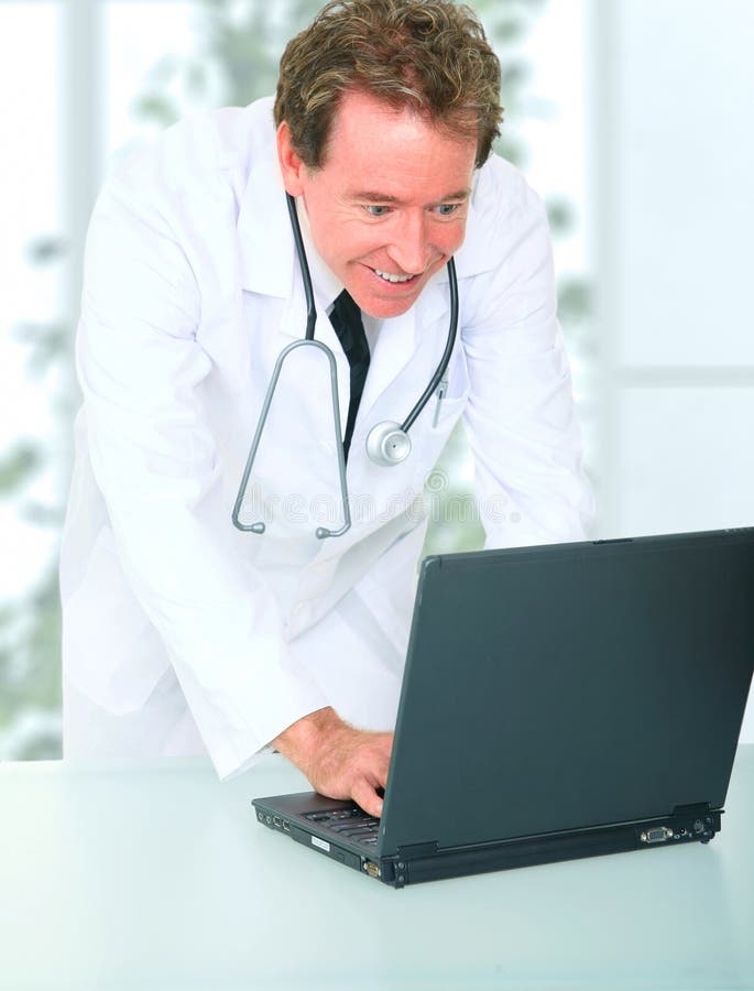 Smiling Senior Doctor Using Laptop in His Office Stock Photo - Image of ...