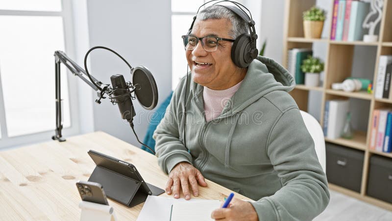 Smiling Senior Man with Headphones Speaking into a Microphone in a ...