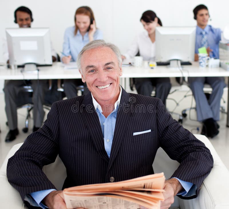 Smiling Senior Manager Reading a Newspaper Stock Image - Image of ...