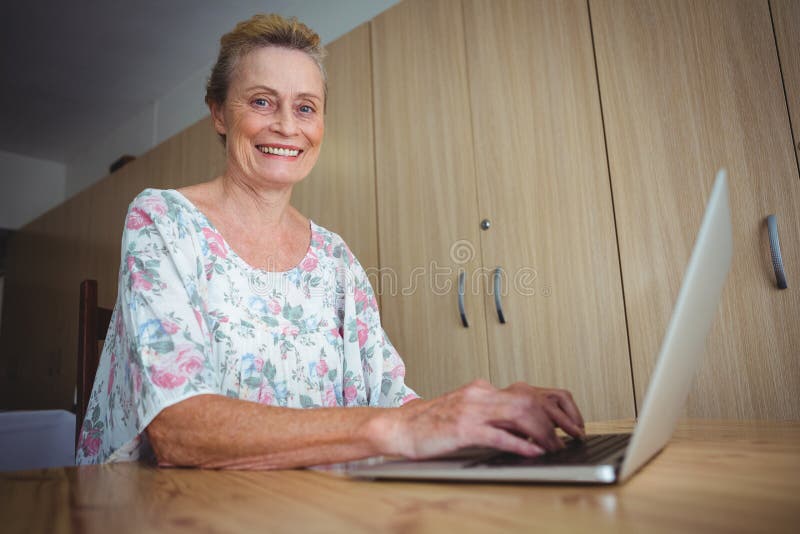Smiling Senior Woman Using a Laptop Stock Image - Image of residential ...
