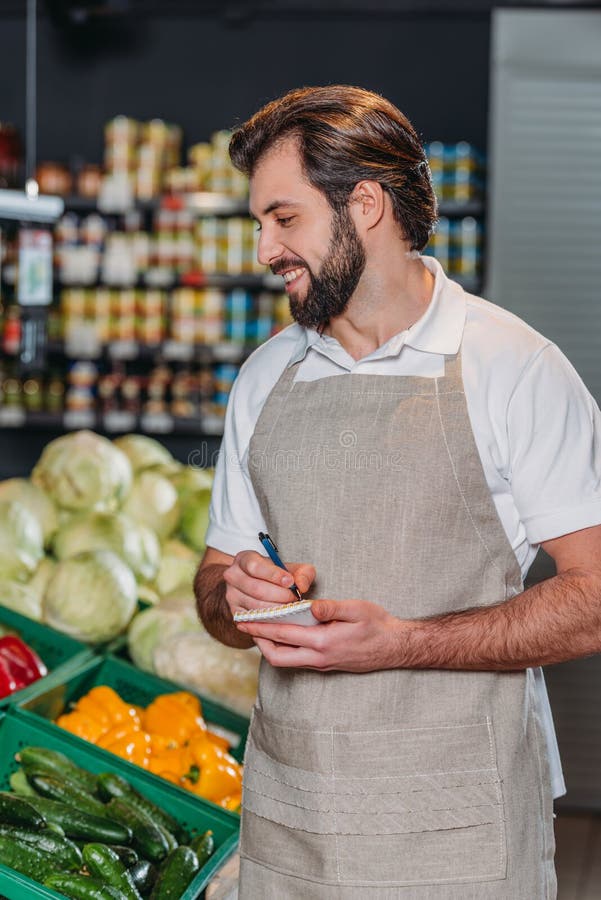 Smiling Shop Assistant in Apron with Notebook Stock Photo - Image of ...
