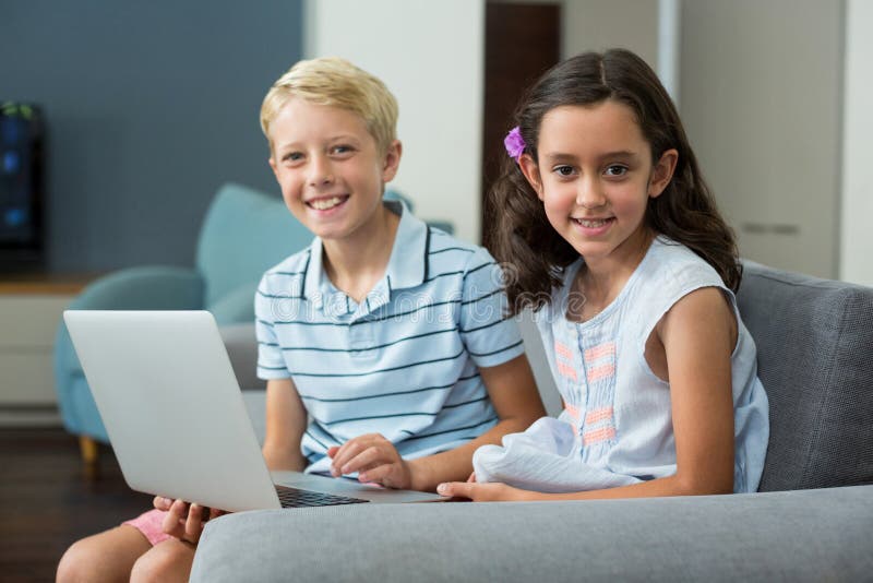 Smiling Siblings Using Laptop in Living Room Stock Image - Image of ...