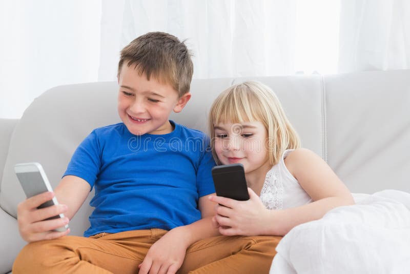 Smiling Siblings Using Mobile Phone Stock Image - Image of domestic ...
