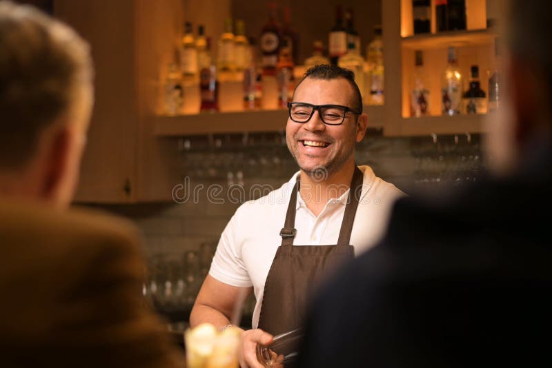 Smiling and Sociable Bartender Conducts a Conversation with Customers ...