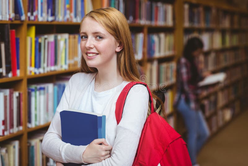 Smiling Student with Backpack Holding a Book in Library Stock Photo ...