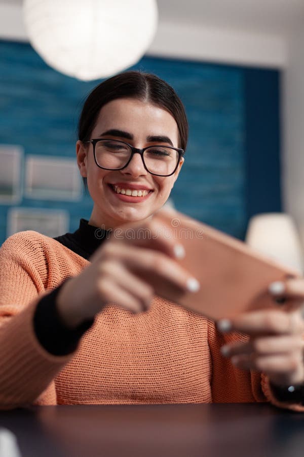 Smiling Student with Glasses Playing Games on Smartphone. Stock Photo ...
