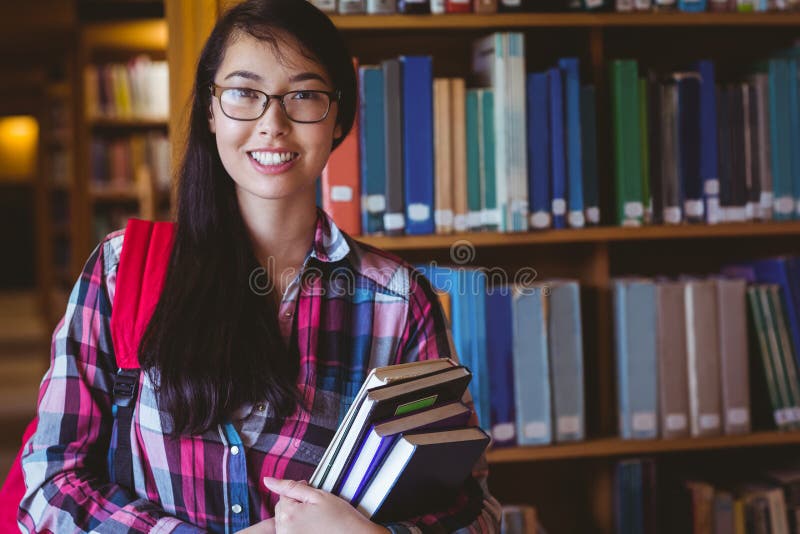 Smiling Student Holding a Book in the Library Stock Photo - Image of ...