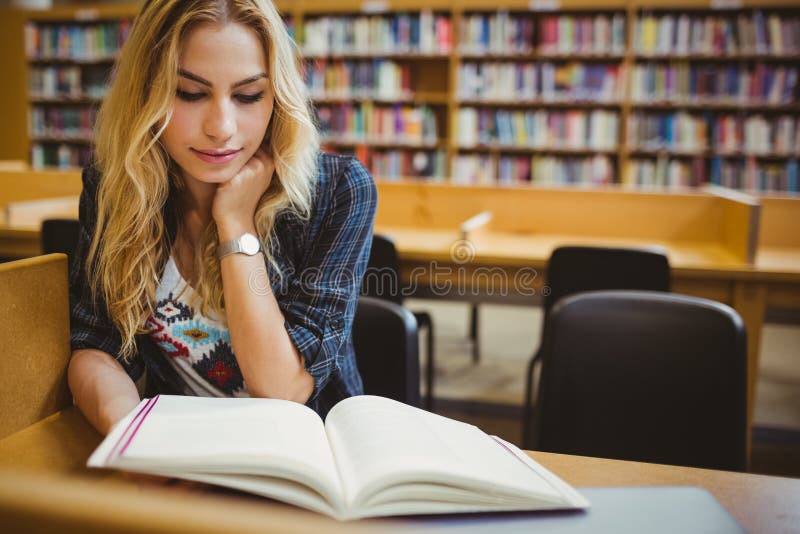 Smiling Student Reading a Book at Table Stock Photo - Image of ...