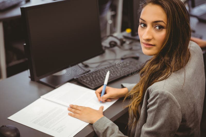 Smiling Student Sitting at Desk Writing on Notepad Stock Photo - Image ...