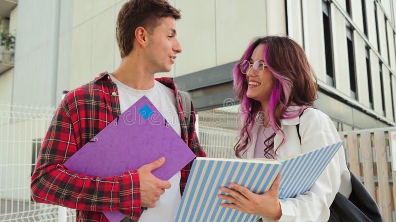 Smiling Students Reviewing Notes Together Outdoors, Holding Notebooks ...