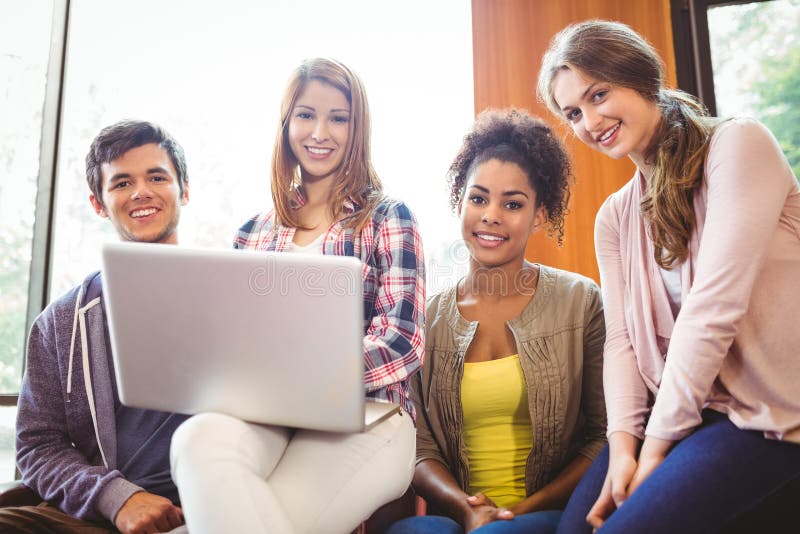 Smiling Students Sitting on Couch Using Laptop Stock Image - Image of ...