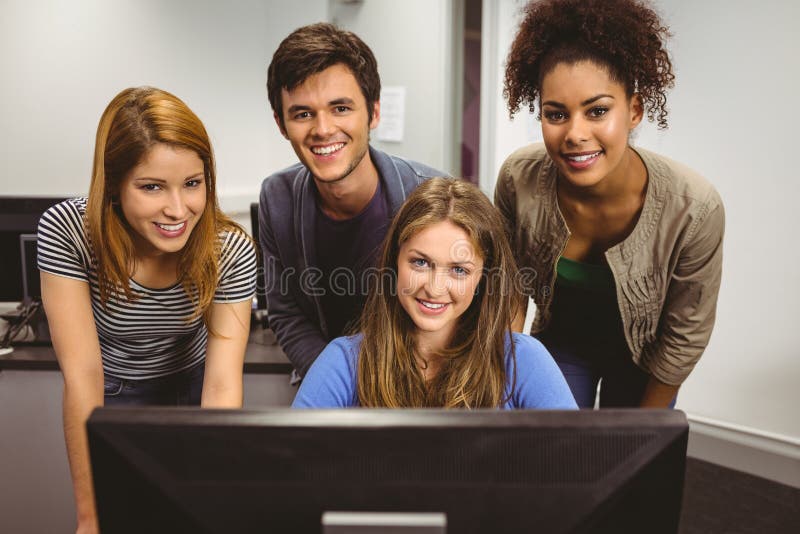 Smiling Students Using Computer Together Looking at Camera Stock Photo ...