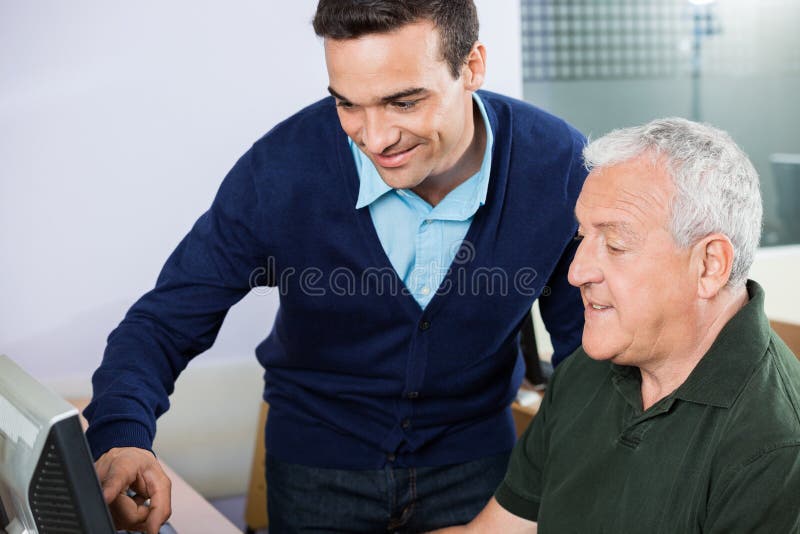 Smiling Teacher Assisting Senior Man in Using Computer Stock Photo ...