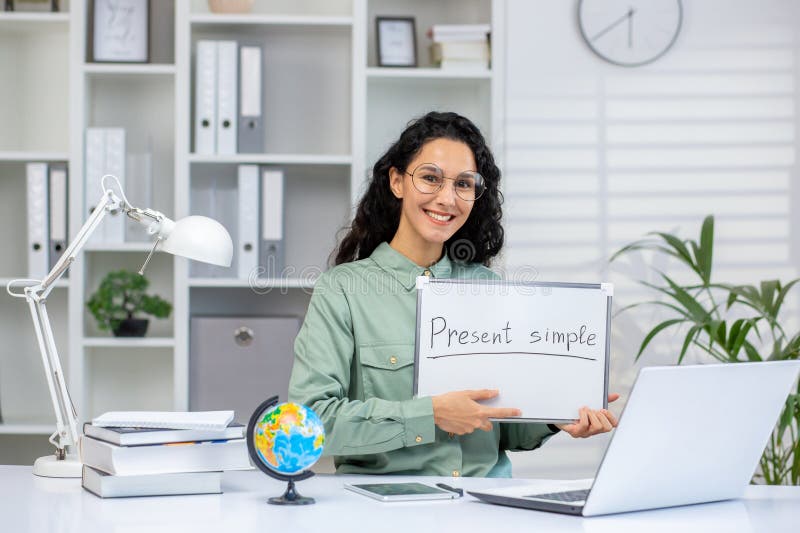 Smiling Teacher Explaining Present Simple Tense in Online Class Stock ...