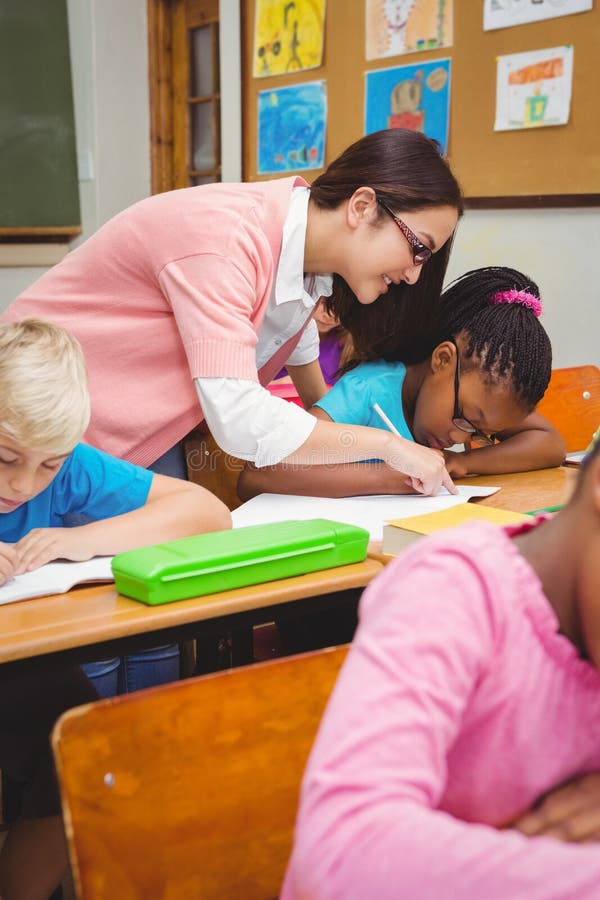 Smiling Teacher Helping a Student Stock Image - Image of elementary ...