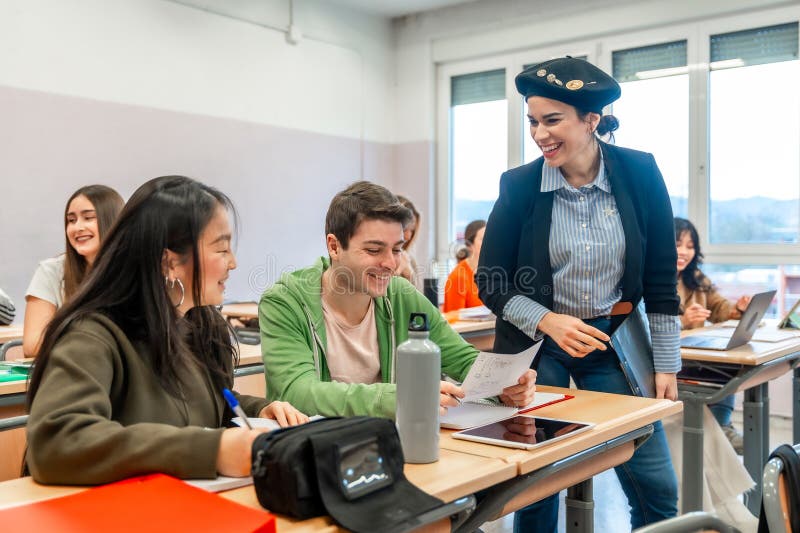 Smiling Teacher Helping Students Studying in University Classroom Stock ...