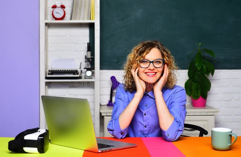 Smiling Teacher or University Professor Sitting at Desk Working with ...