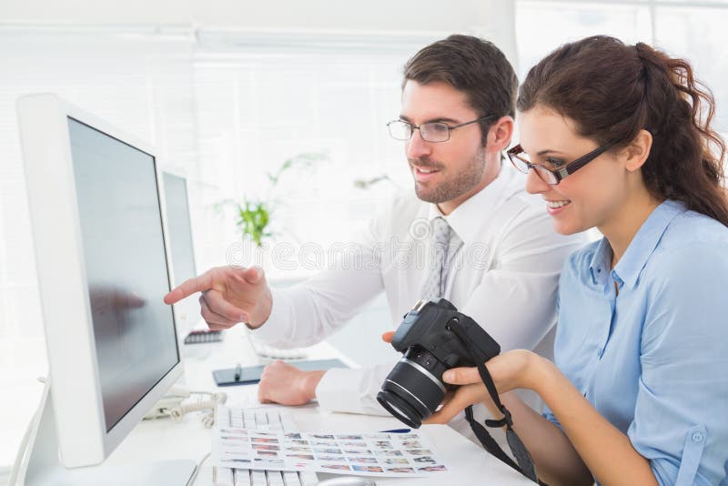 Smiling Team Working with Computer and Digital Camera Stock Image ...