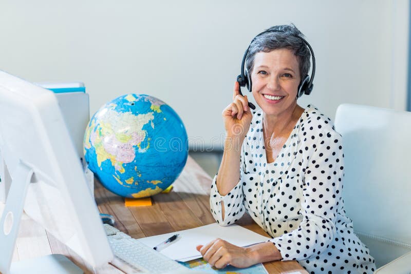 Smiling Travel Agent Sitting at Her Desk Stock Photo - Image of ...