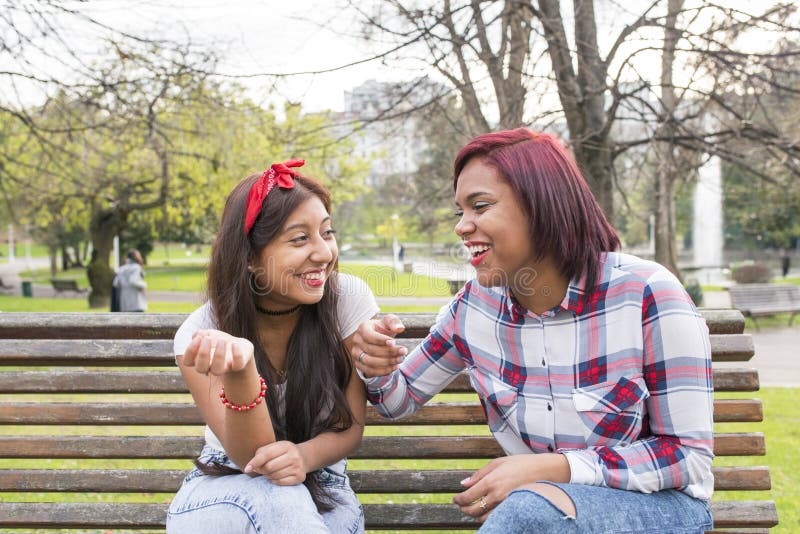 Two Friends Talking and Laughing in a Park Stock Photo - Image of ...
