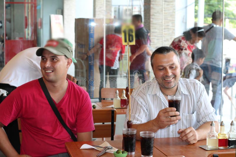 Smiling Two Men at a Cafe Table Stock Image - Image of waiting, smiling ...