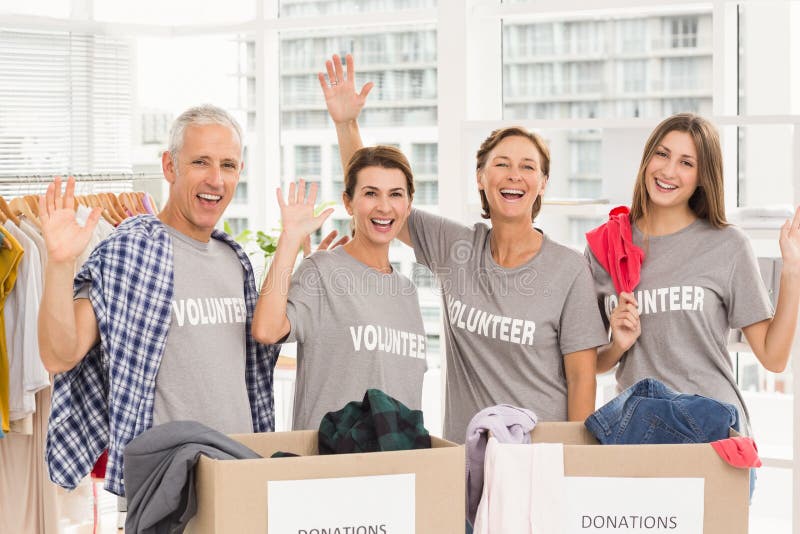 Smiling volunteers waving stock image. Image of mature - 58186557