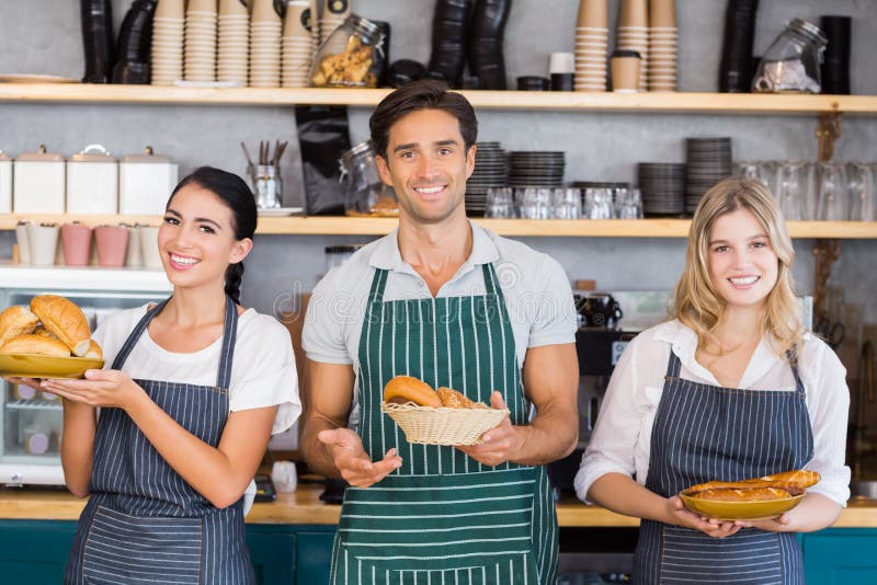 Smiling Waiter and Two Waitresses Holding Plate of Bread Rolls Stock ...