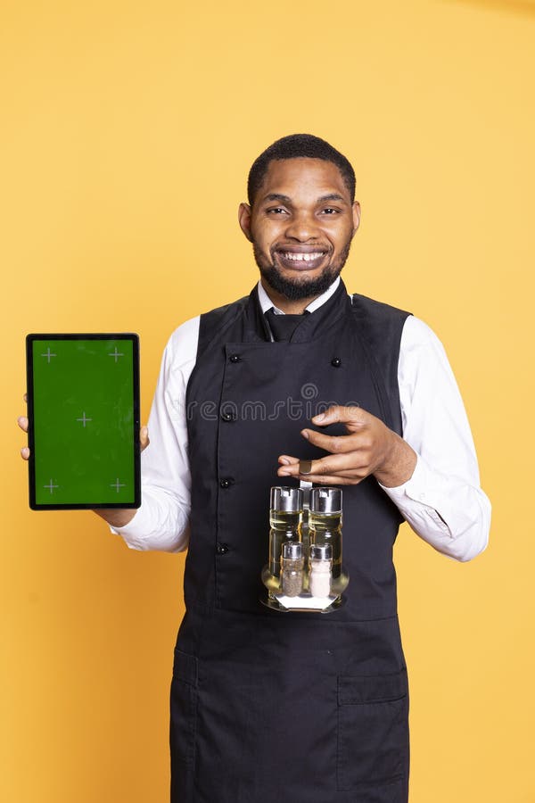 Smiling Waiter in Uniform Presenting a Device with Isolated Chroma Key ...
