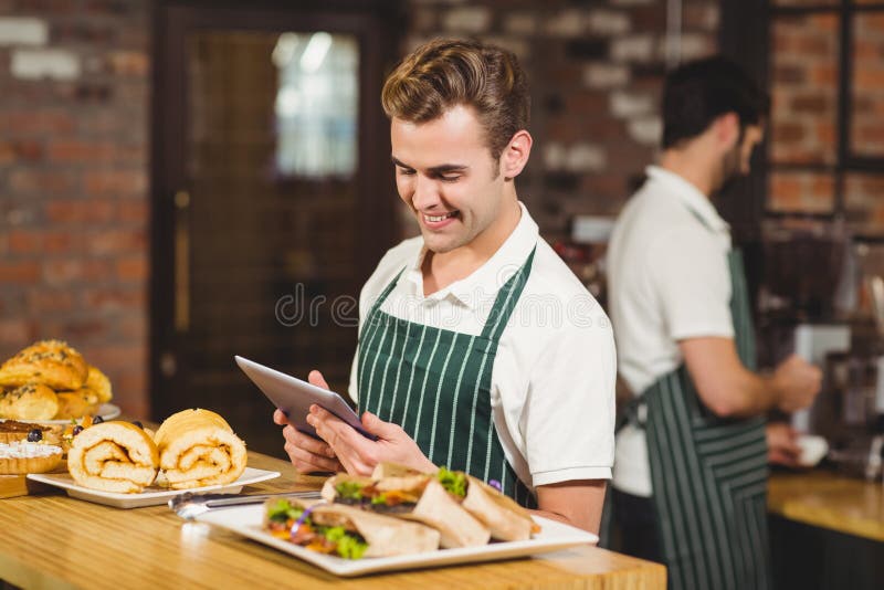 Smiling Waiter Using a Digital Tablet Stock Photo - Image of indoors ...