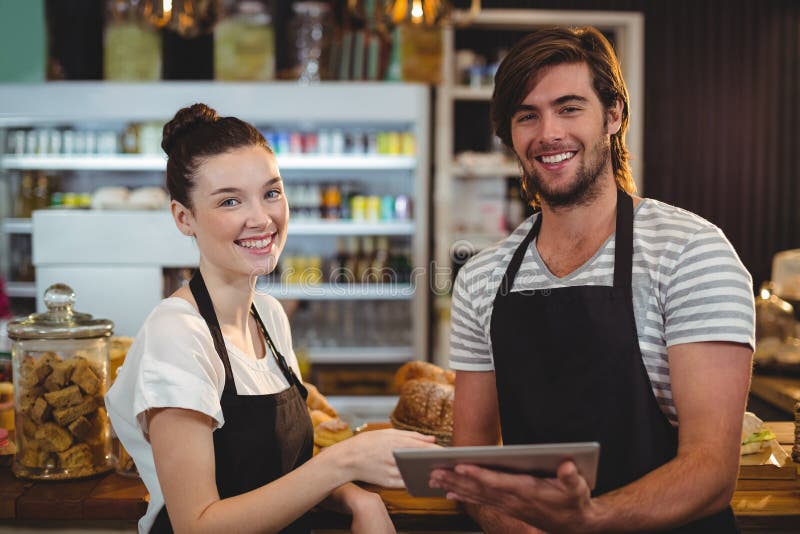 Smiling Waiter and Waitress Using Digital Tablet at Counter Stock Photo ...