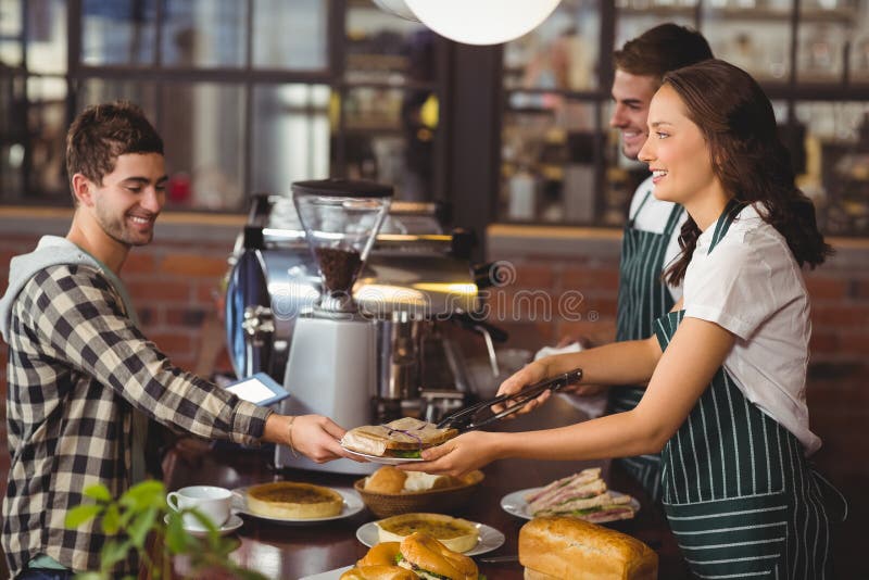 Smiling Waiters Serving a Client Stock Image - Image of handing ...
