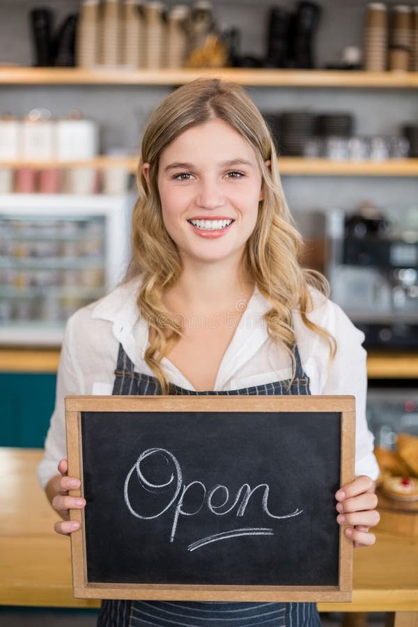 Smiling Waitress Showing Chalkboard with Open Sign at Cafe Stock Photo ...