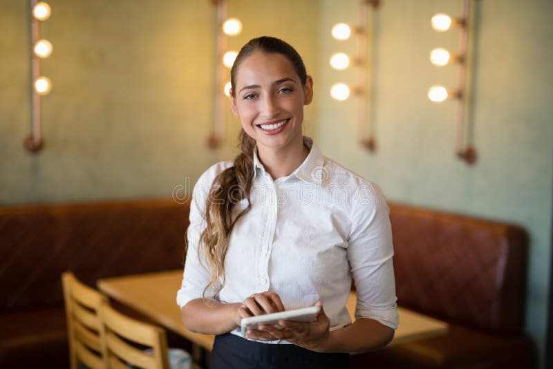Smiling Waitress Using Digital Tablet in Bar Stock Image - Image of ...