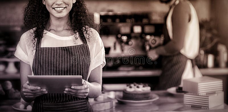 Waitress Using Digital Tablet while Waiter Preparing Coffee in ...