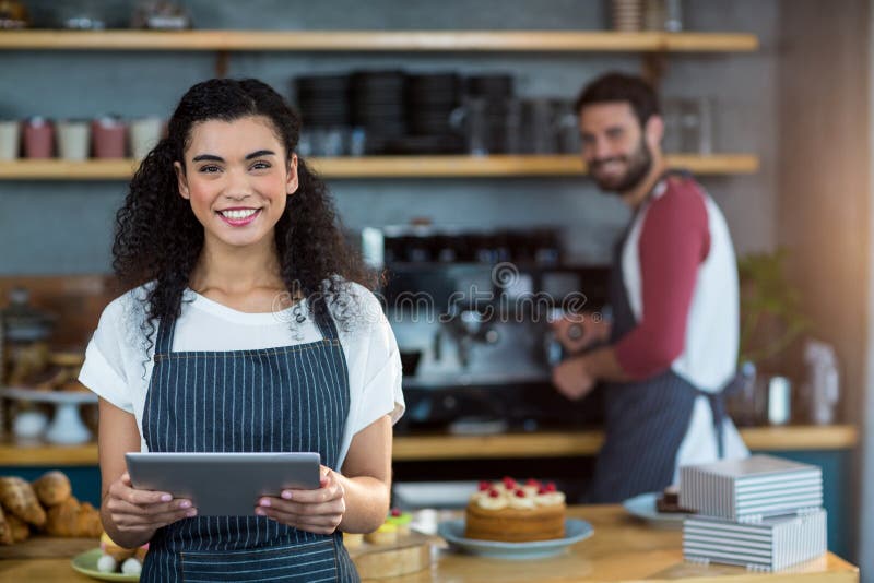 Waitress Using Digital Tablet while Waiter Preparing Coffee in ...