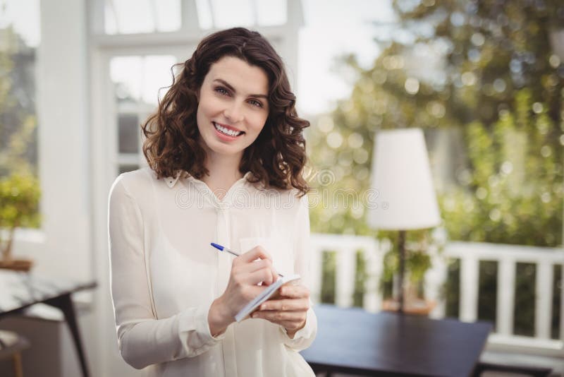 Smiling Waitress Writing on Note Pad in Restaurant Stock Image - Image ...