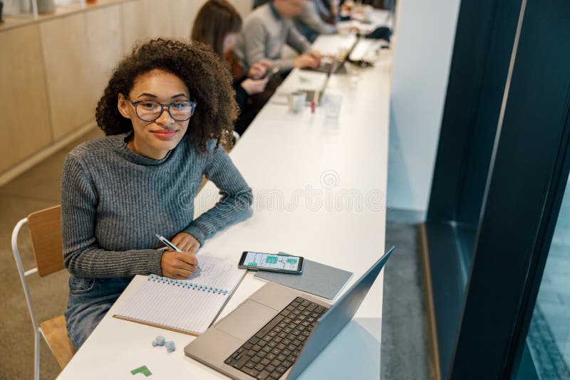Smiling Woman Freelancer Working Laptop And Making Notes While Sitting