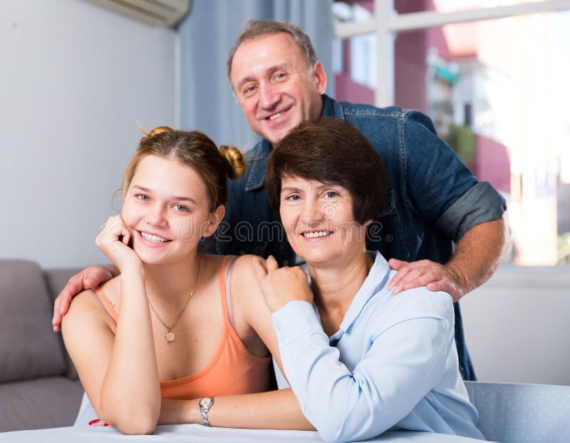 Smiling Woman with Her Parents are Posing at the Table Stock Photo ...